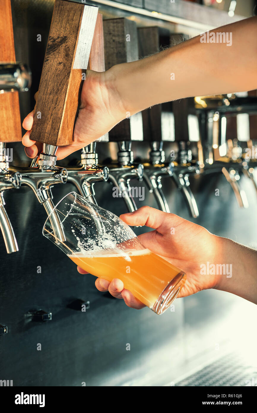Hand of bartender pouring a large lager beer in tap Stock Photo - Alamy