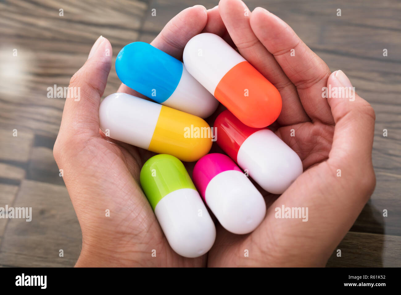 Hand With Colorful Oversized Medicine Pills Stock Photo - Alamy