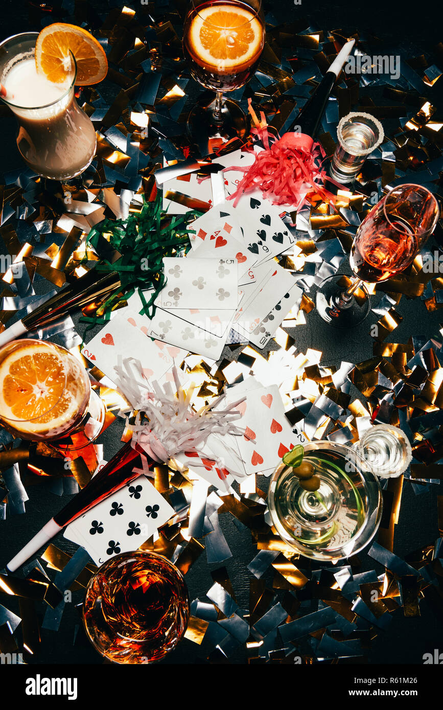 elevated view of playing cards, alcoholic cocktails with orange slices ...