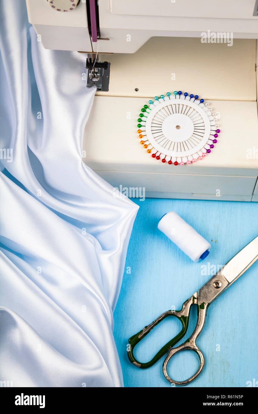 Sewing machine and white satin fabric close-up Stock Photo - Alamy
