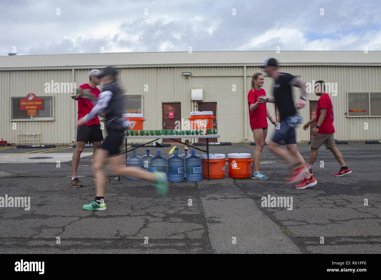 Volunteers hand out water to runners at the 5 kilometer point aboard ...