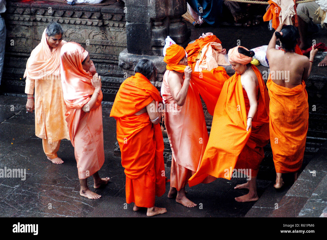 Pilgrims change to saffron clothes after their holy dip at ...