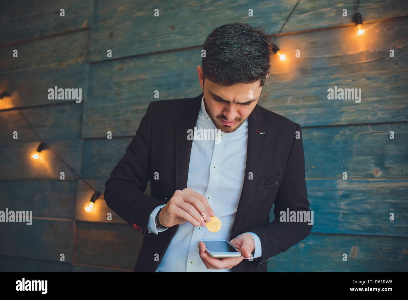 young man holding bitcoin in hand white background Stock Photo - Alamy