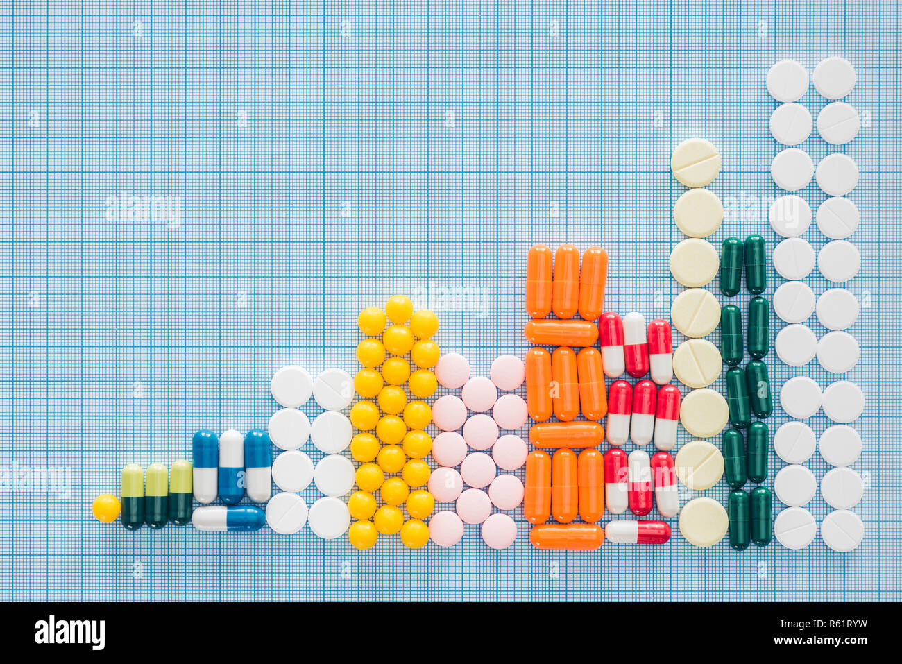 top view of graph from various colorful pills on blue checkered surface ...
