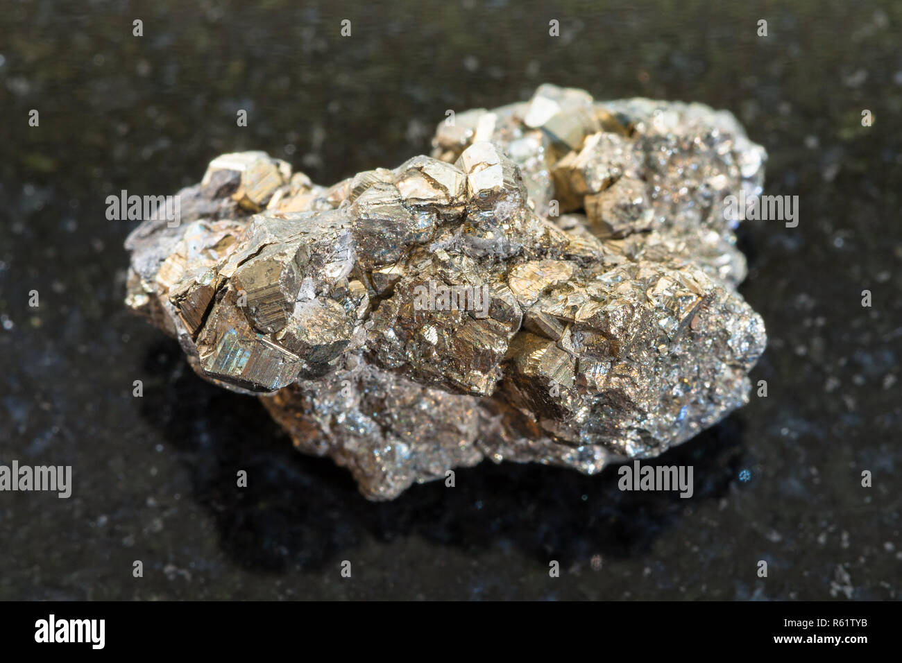 raw pyrite stone on dark background Stock Photo - Alamy