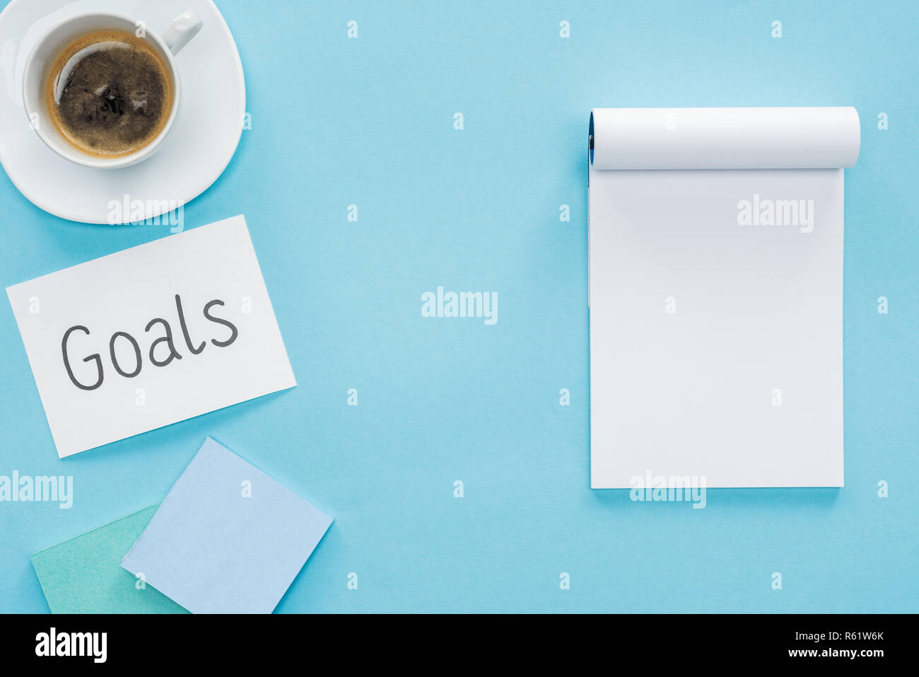 top view of card with 'goals' lettering, blank notebook and cup of ...