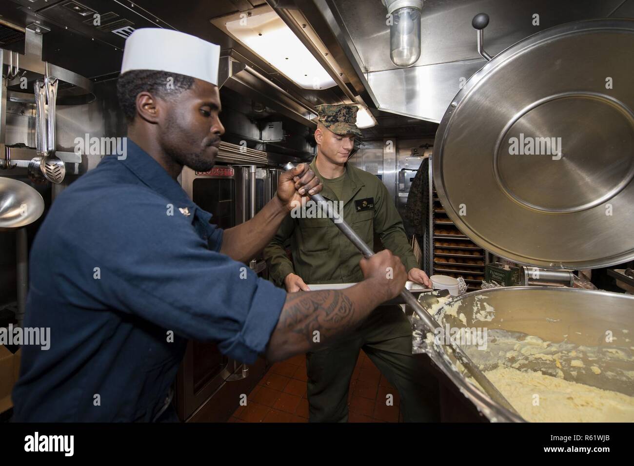 Marine Cpl. Christian Arnett readies a serving tray while Culinary ...
