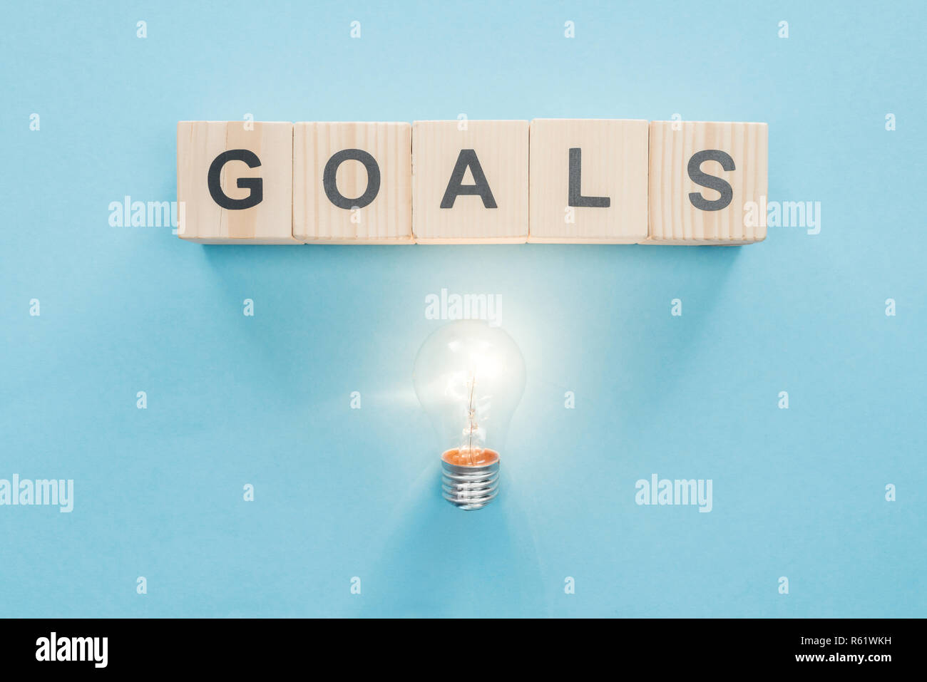 top view of glowing light bulb under 'goals' word made of wooden blocks ...
