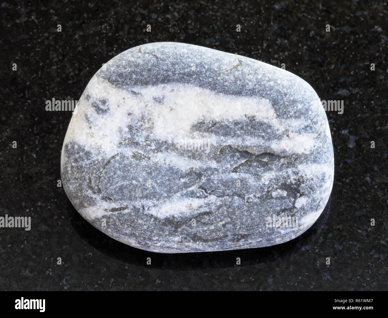 pebble of gray Gneiss stone on dark Stock Photo - Alamy