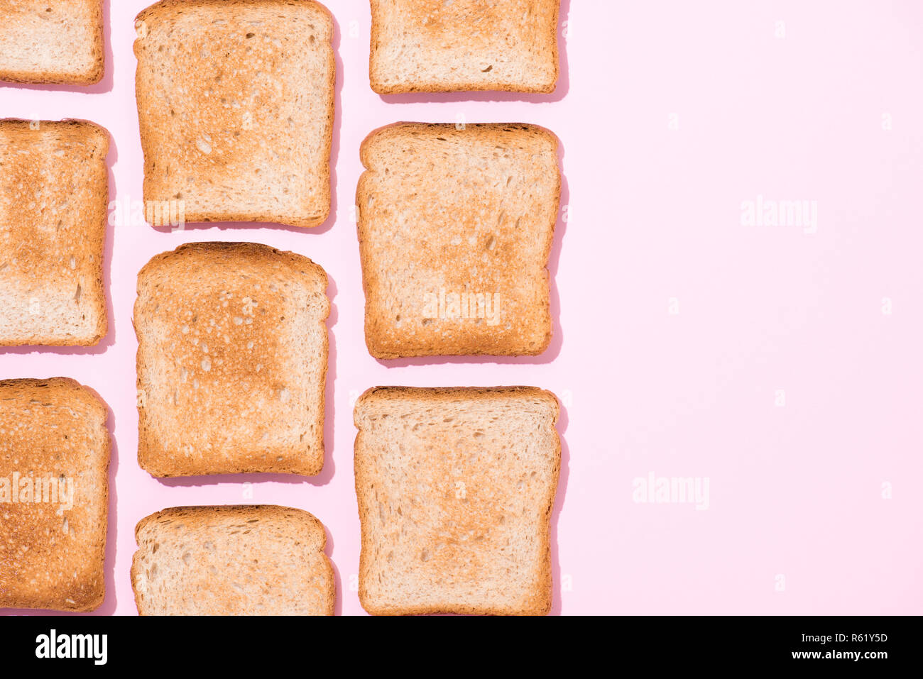 top view of rows of crispy toasts on pink surface Stock Photo - Alamy
