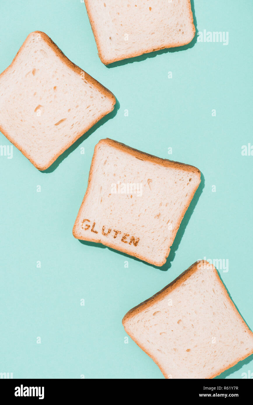top view of messy spilled bread slices with burned gluten sign on blue ...
