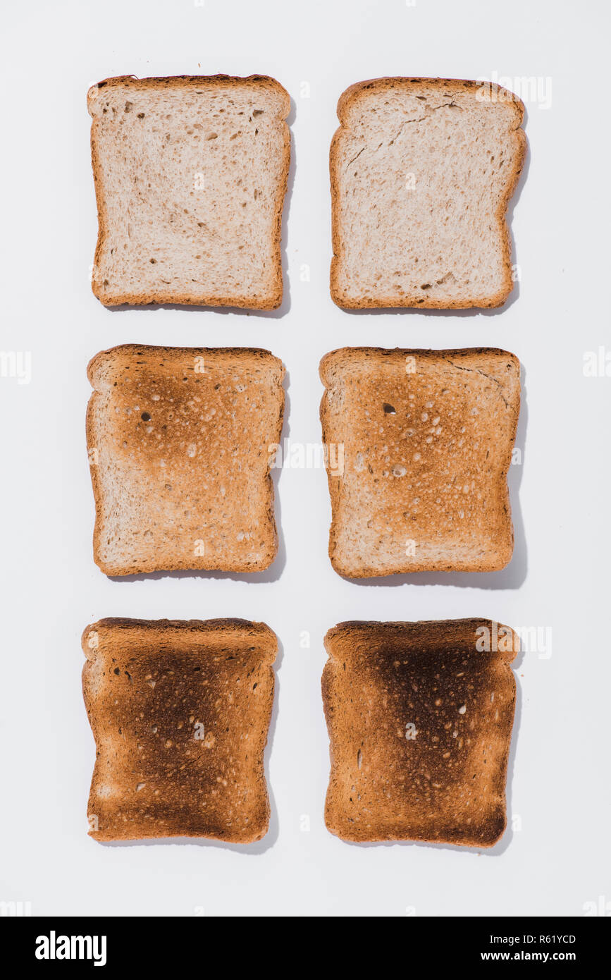 top view of rows of toasts in various roast stages on white surface ...