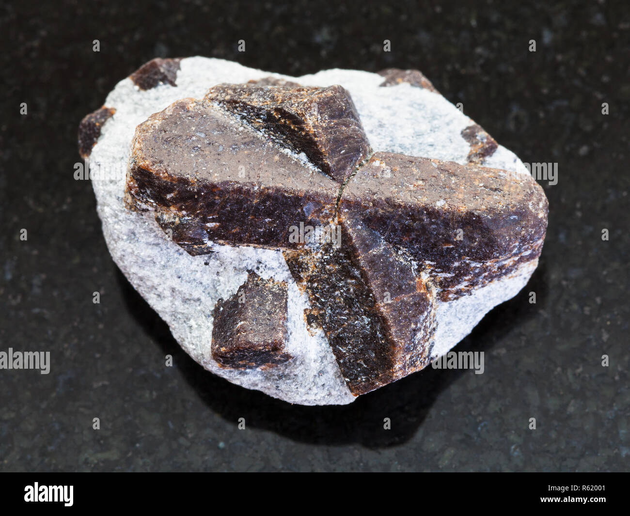 raw crystal of Staurolite in mica shale on dark Stock Photo - Alamy