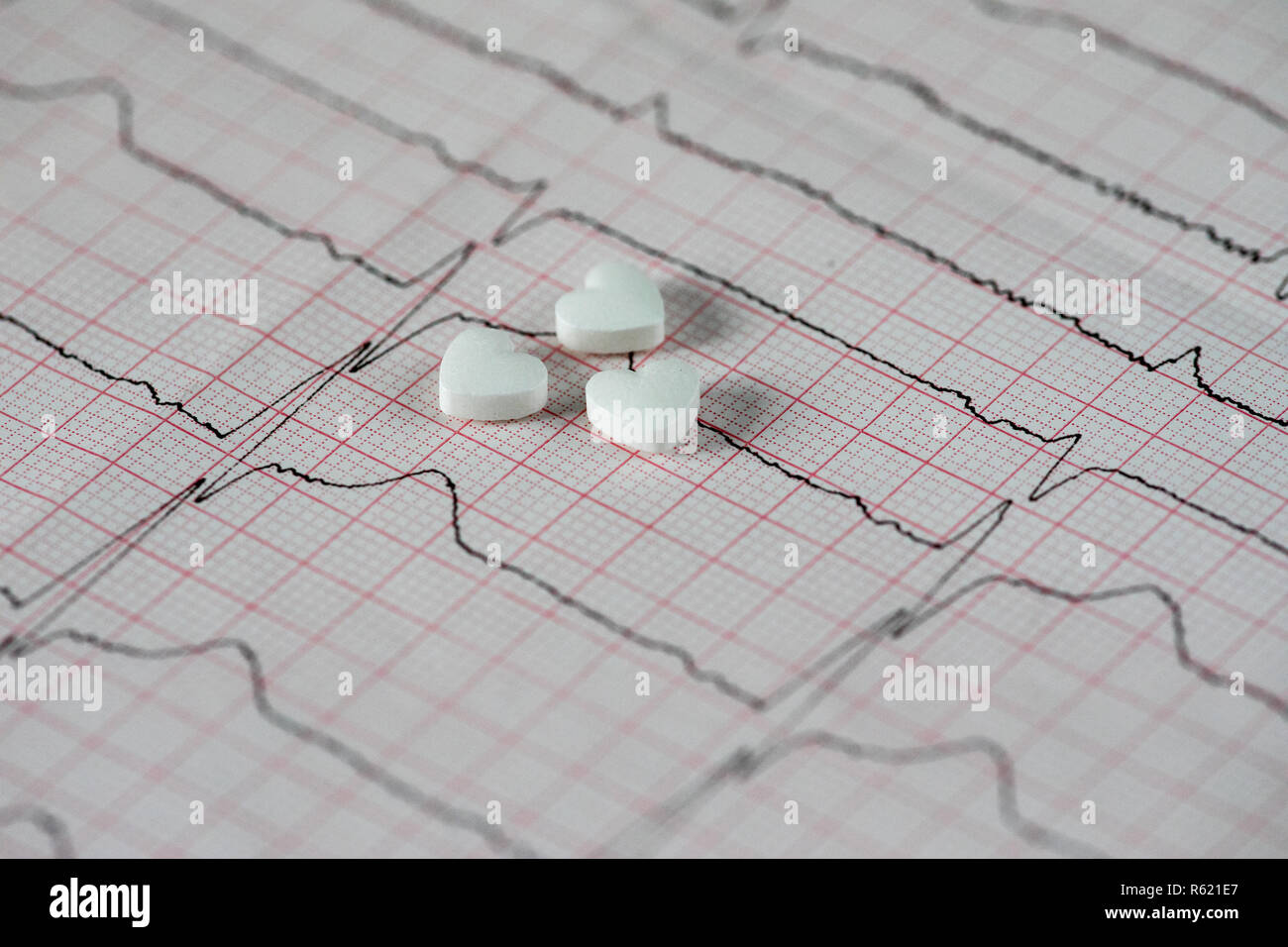 Cardiology. Macro of ECG graph and cardio pills. Pills as a heart Stock ...