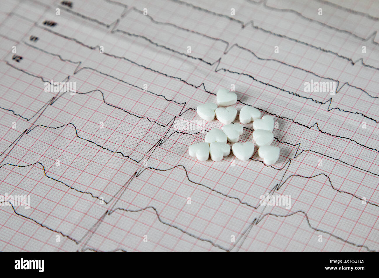 Cardiology. Macro of ECG graph and cardio pills. Pills as a heart Stock ...