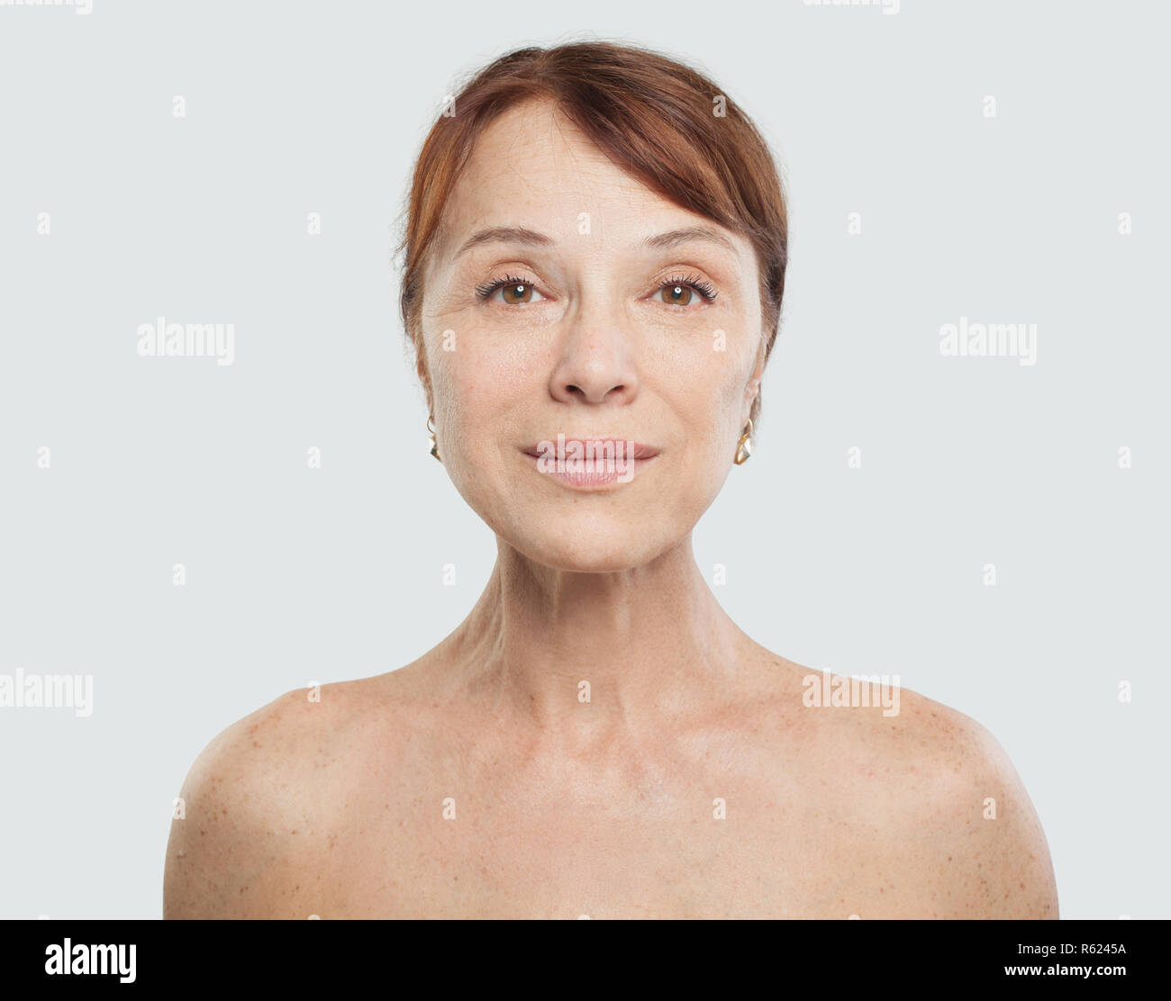 Mid adult woman face on white background. Facial treatment, aesthetic ...