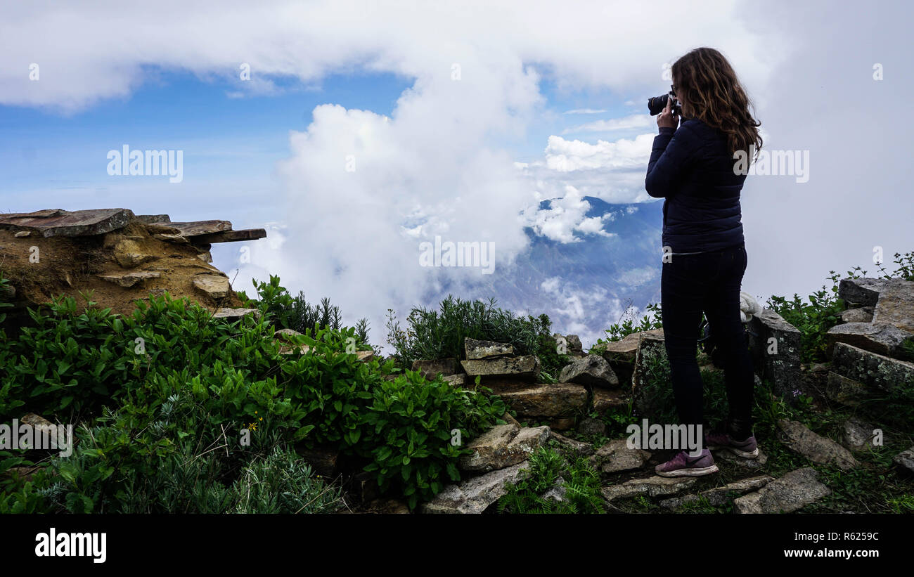 Girl taking photos of the ruins over the clouds in Rupac, Peru, South ...