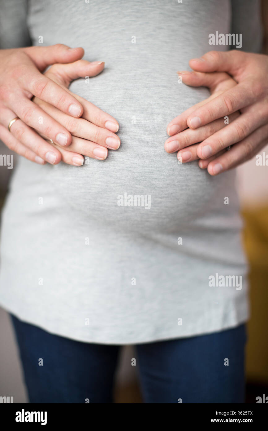 Close Up Of Male And Female Hands Resting On Pregnant Womans Stomach ...