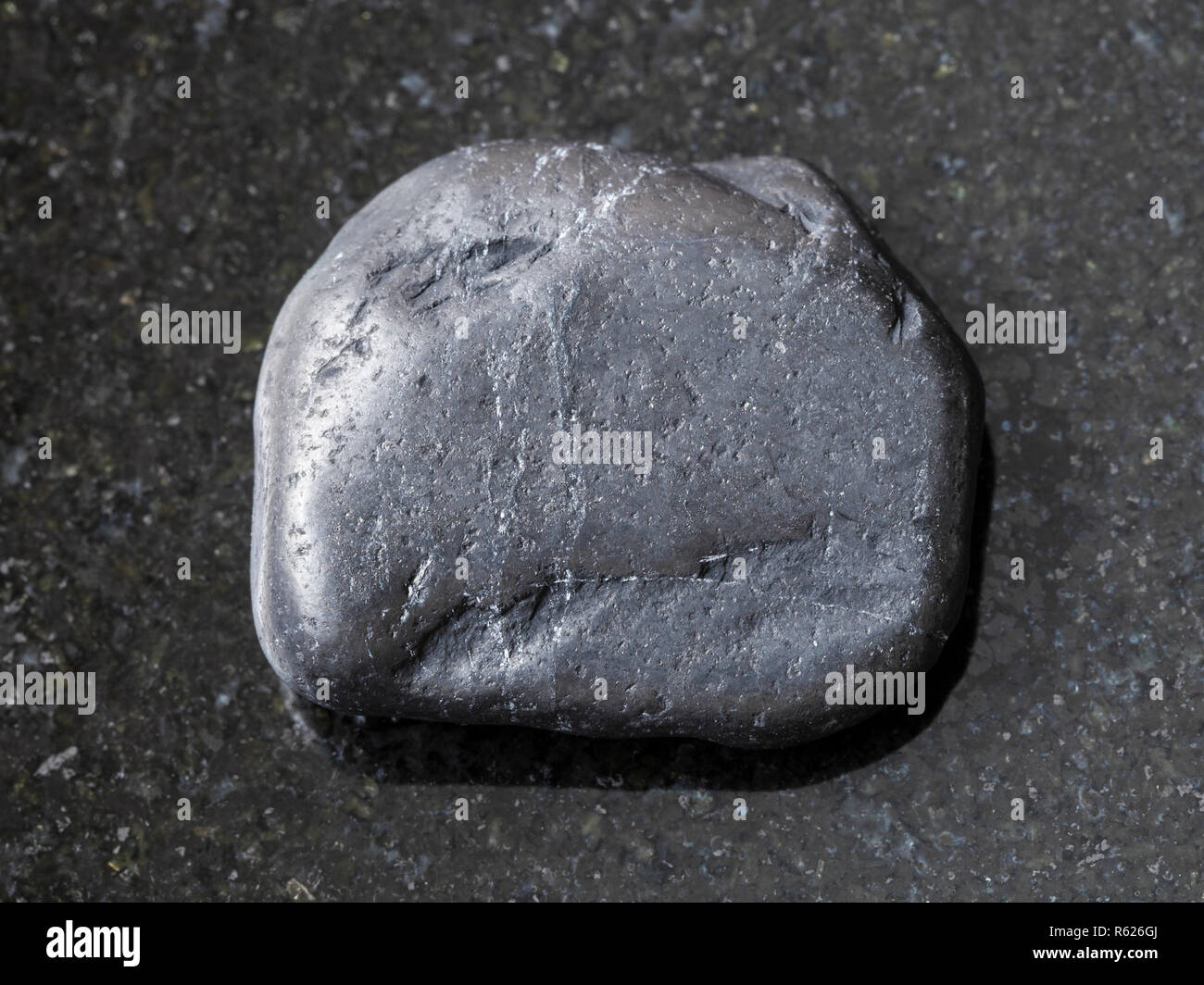 tumbled shungite gemstone on dark background Stock Photo - Alamy