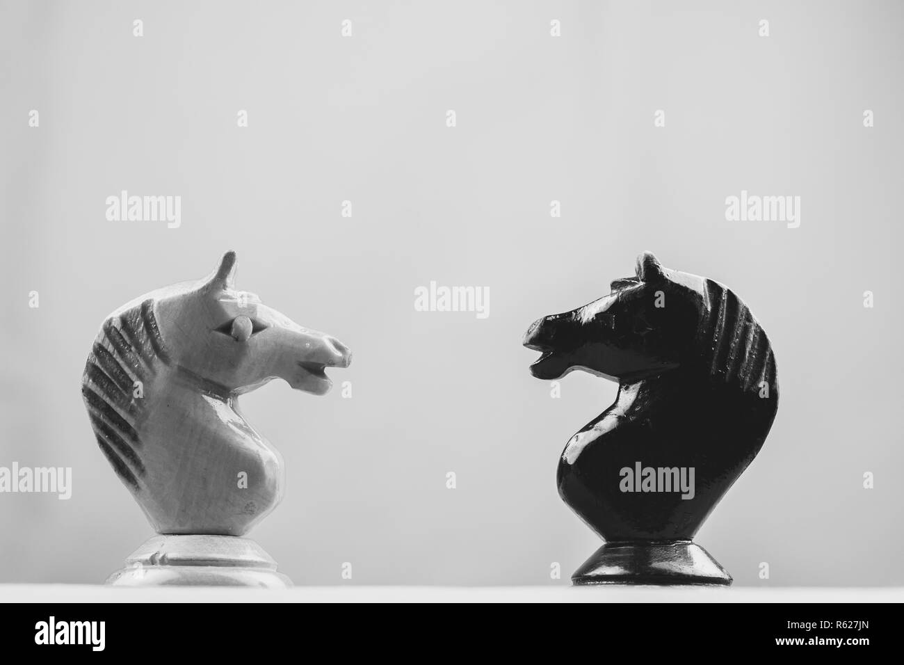 Chess knights face to face on grey background Stock Photo - Alamy