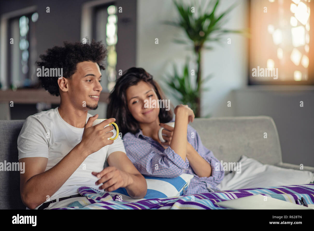 Young couple with laptop lying on a hotel bed hi-res stock photography ...