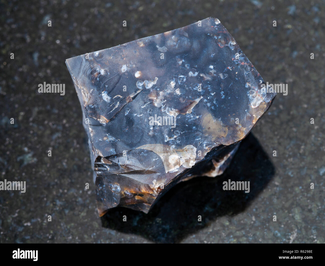 raw black Flint stone on dark background Stock Photo - Alamy