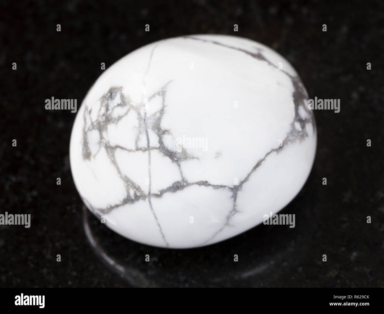 tumbled howlite gemstone on dark background Stock Photo - Alamy