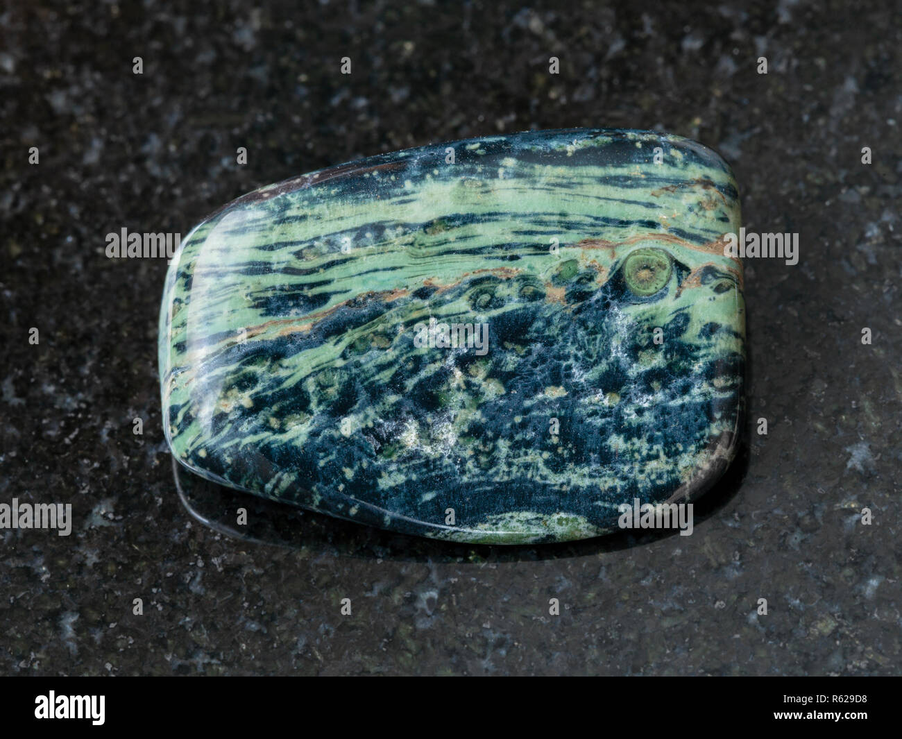 tumbled rhyolite gemstone on dark background Stock Photo - Alamy