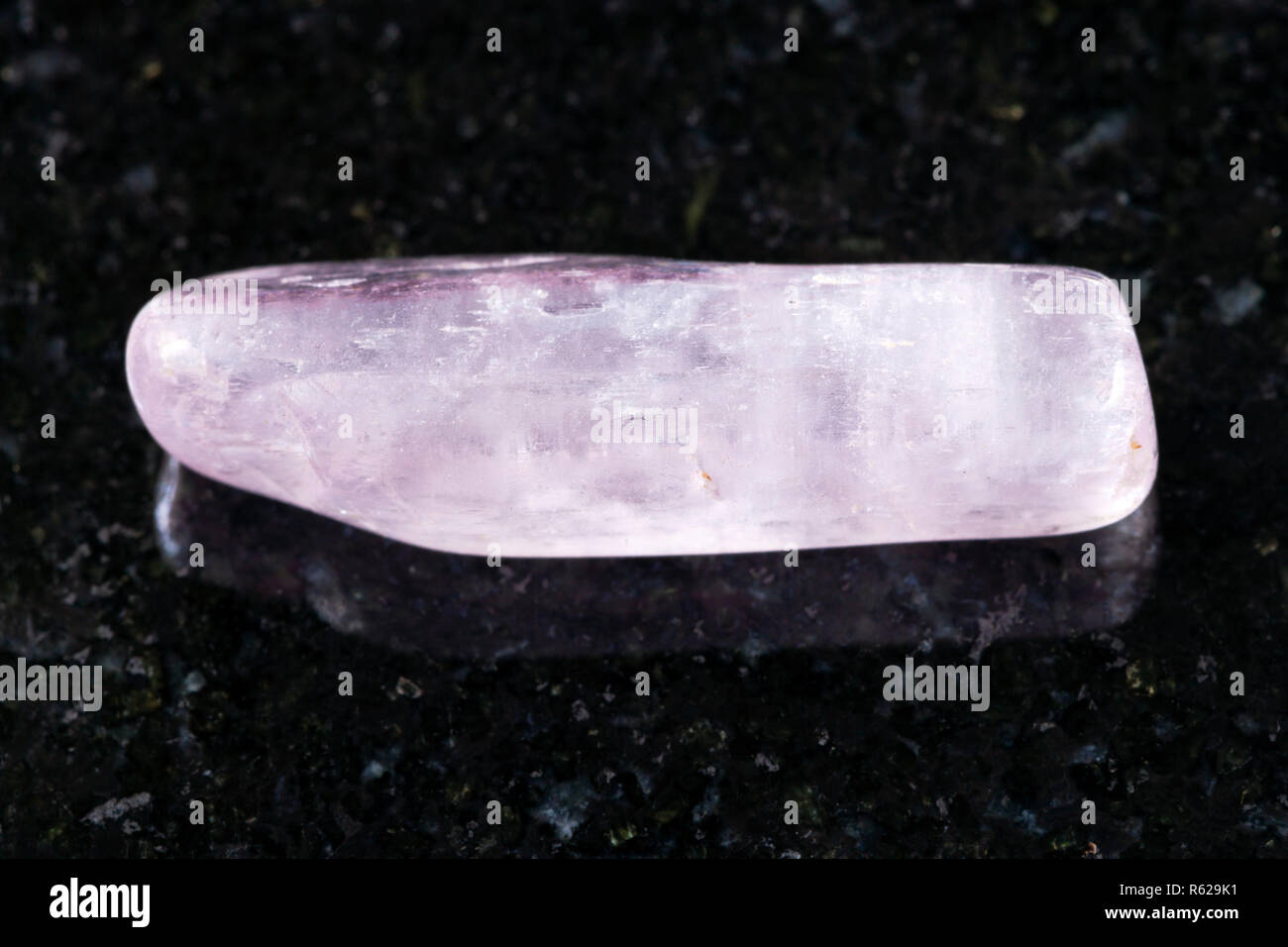 tumbled kunzite gemstone on dark background Stock Photo - Alamy