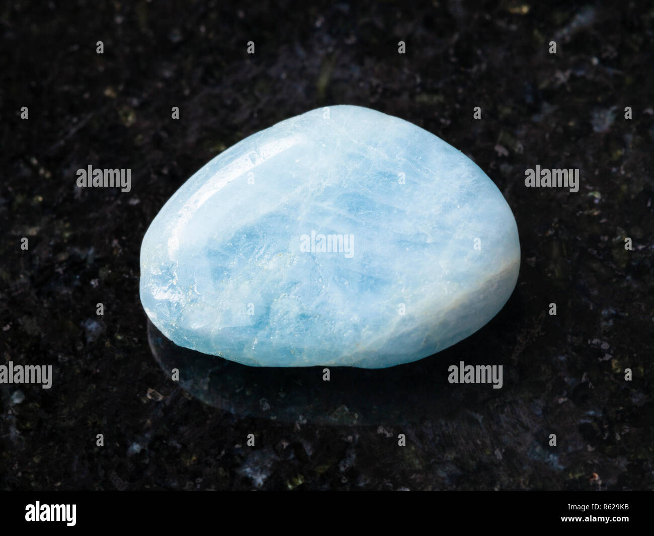tumbled aquamarine (blue beryl) gem stone on dark Stock Photo - Alamy