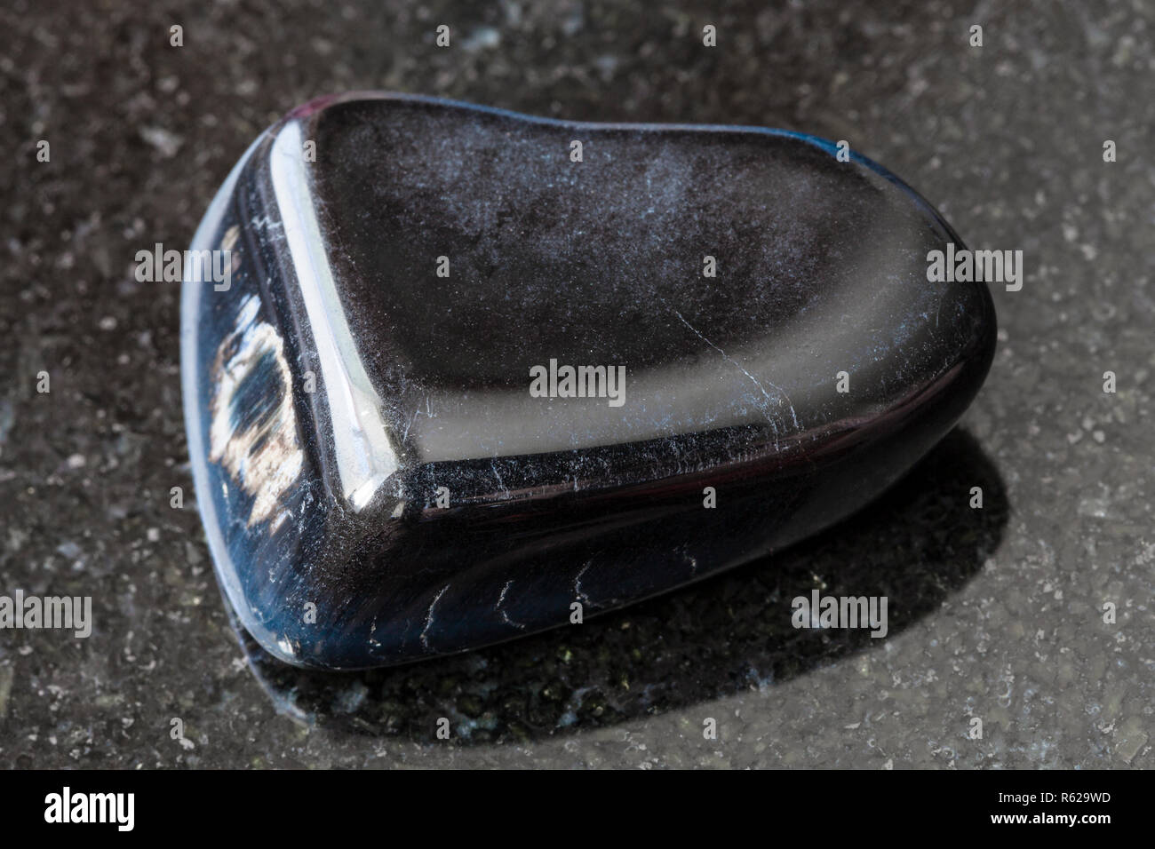 tumbled hawk-eye gemstone on dark background Stock Photo - Alamy