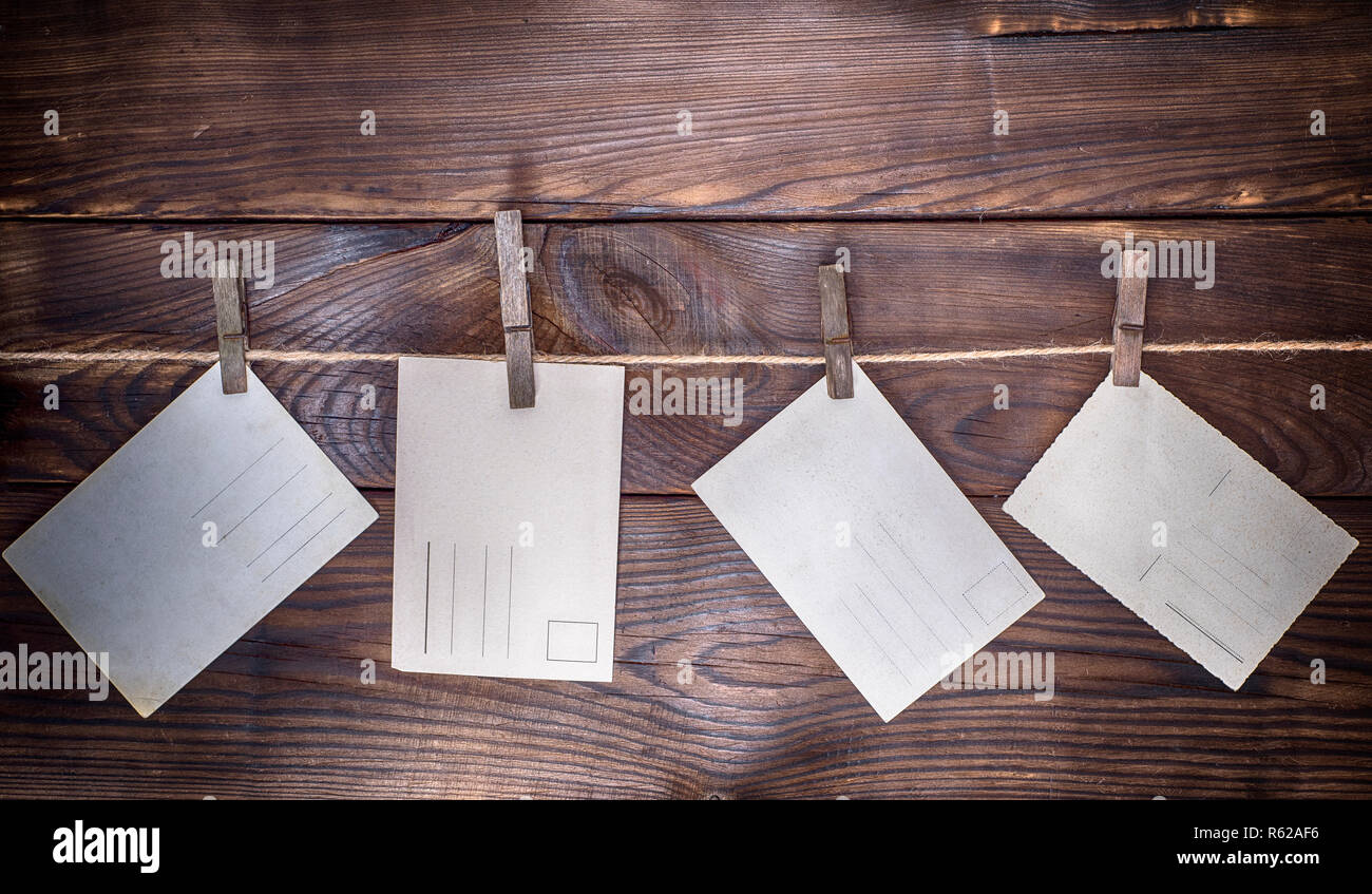 four empty paper postcards hang on a rope Stock Photo - Alamy