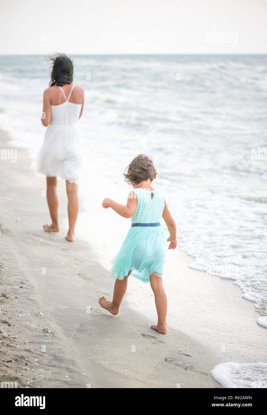 The little girl is trying to walk in the footsteps of her mother ...
