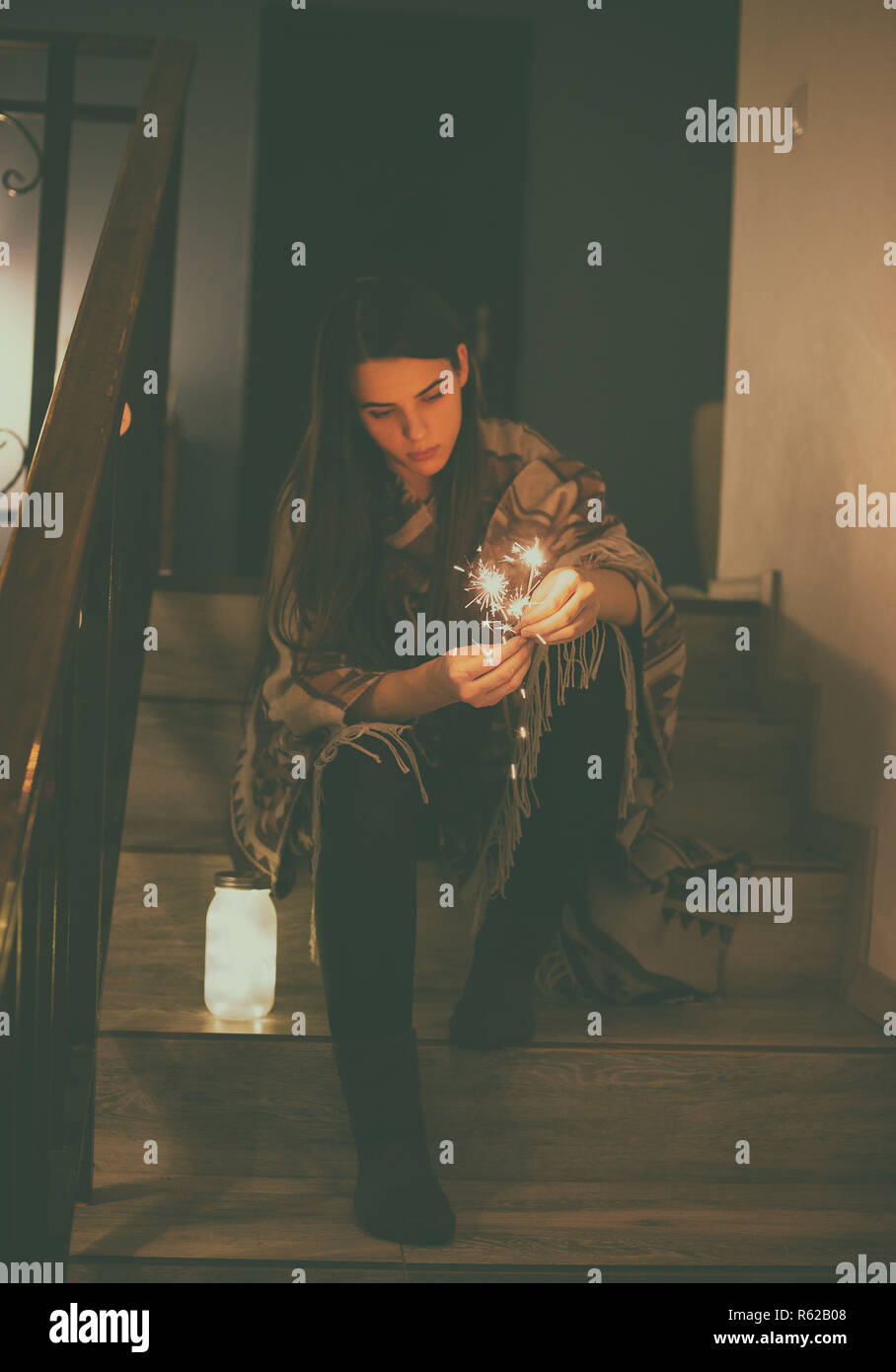 young woman sitting on stairs and lights fireworks Stock Photo - Alamy
