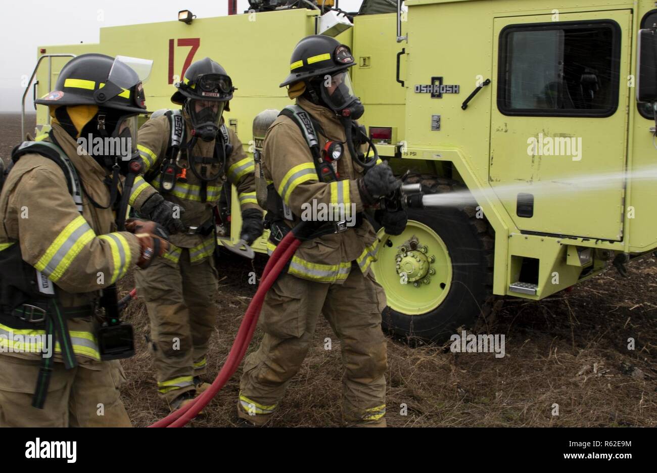 Canadian Armed Forces firefighters use teamwork to extinguish a ...