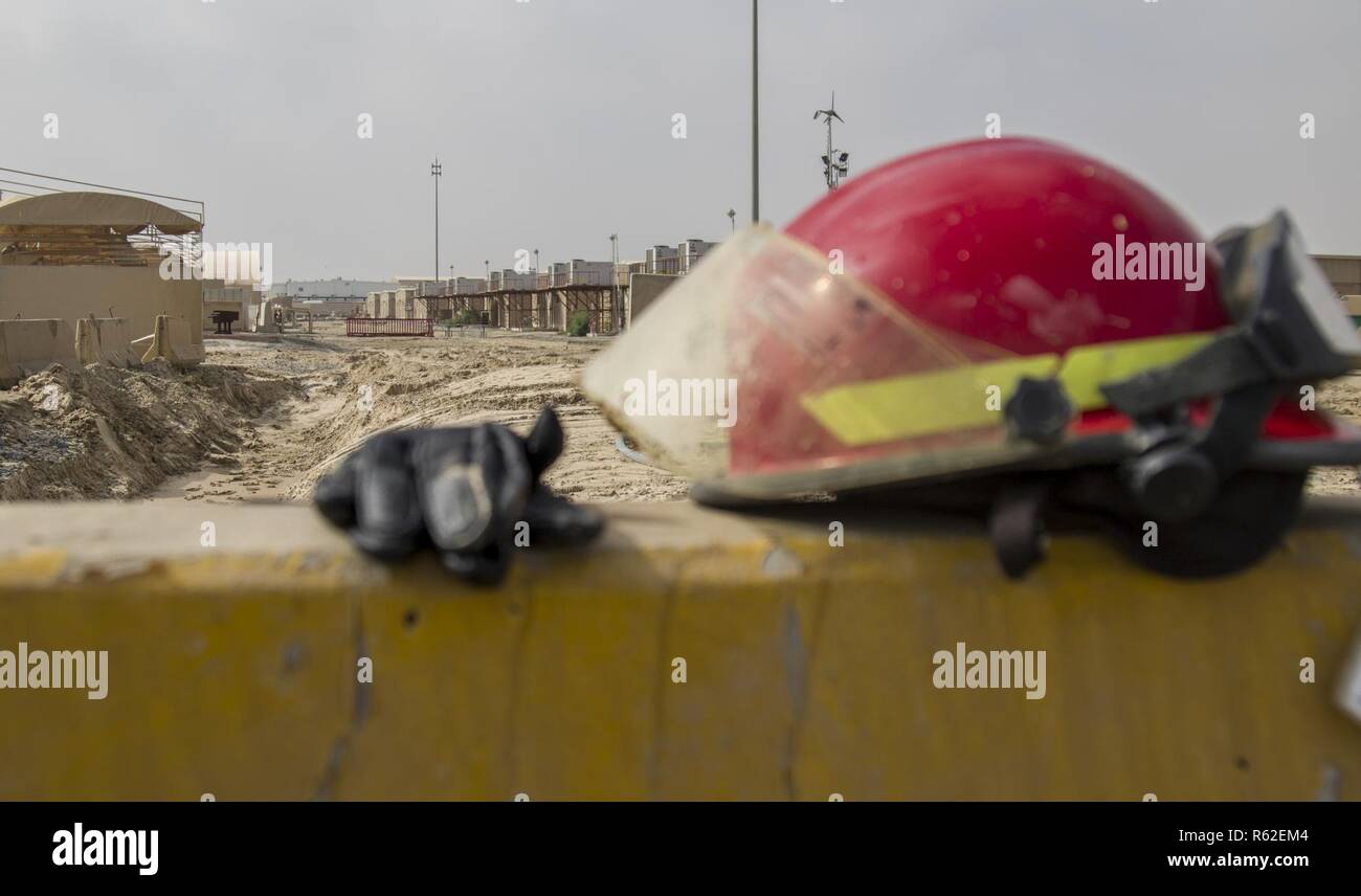A firefighter’s helmet rests on a barrier in front of a drainage ditch ...