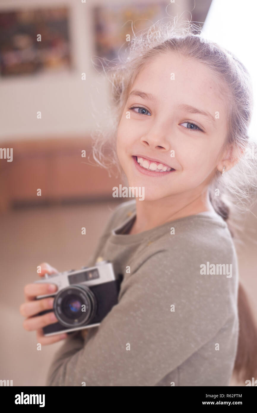Girl with a retro camera makes a photo, studio shot Stock Photo - Alamy