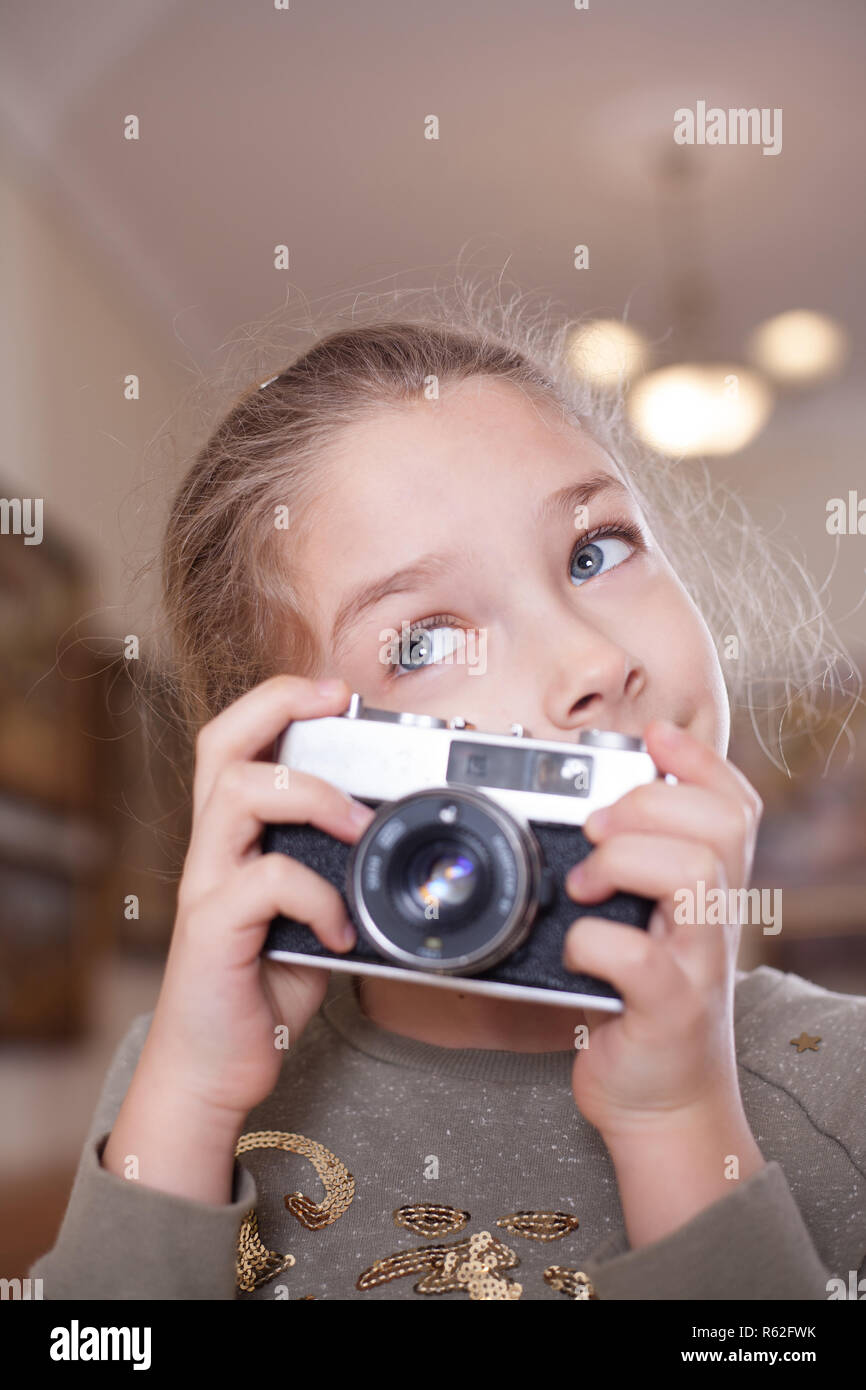 Girl with a retro camera makes a photo, studio shot Stock Photo - Alamy