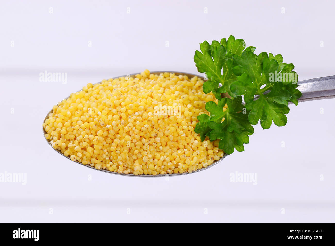 spoon of raw millet grains Stock Photo - Alamy