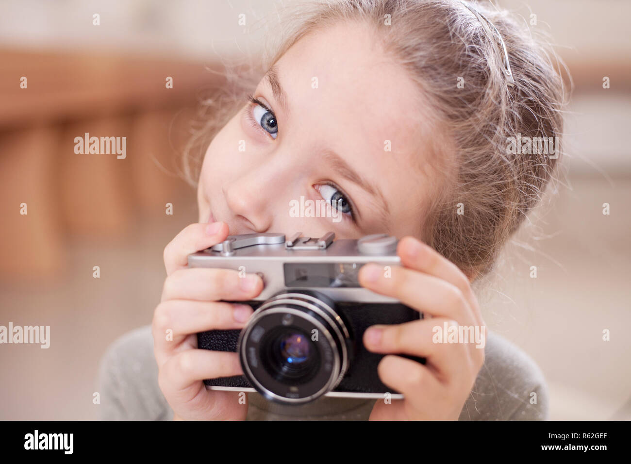 Girl with a retro camera makes a photo, studio shot Stock Photo - Alamy