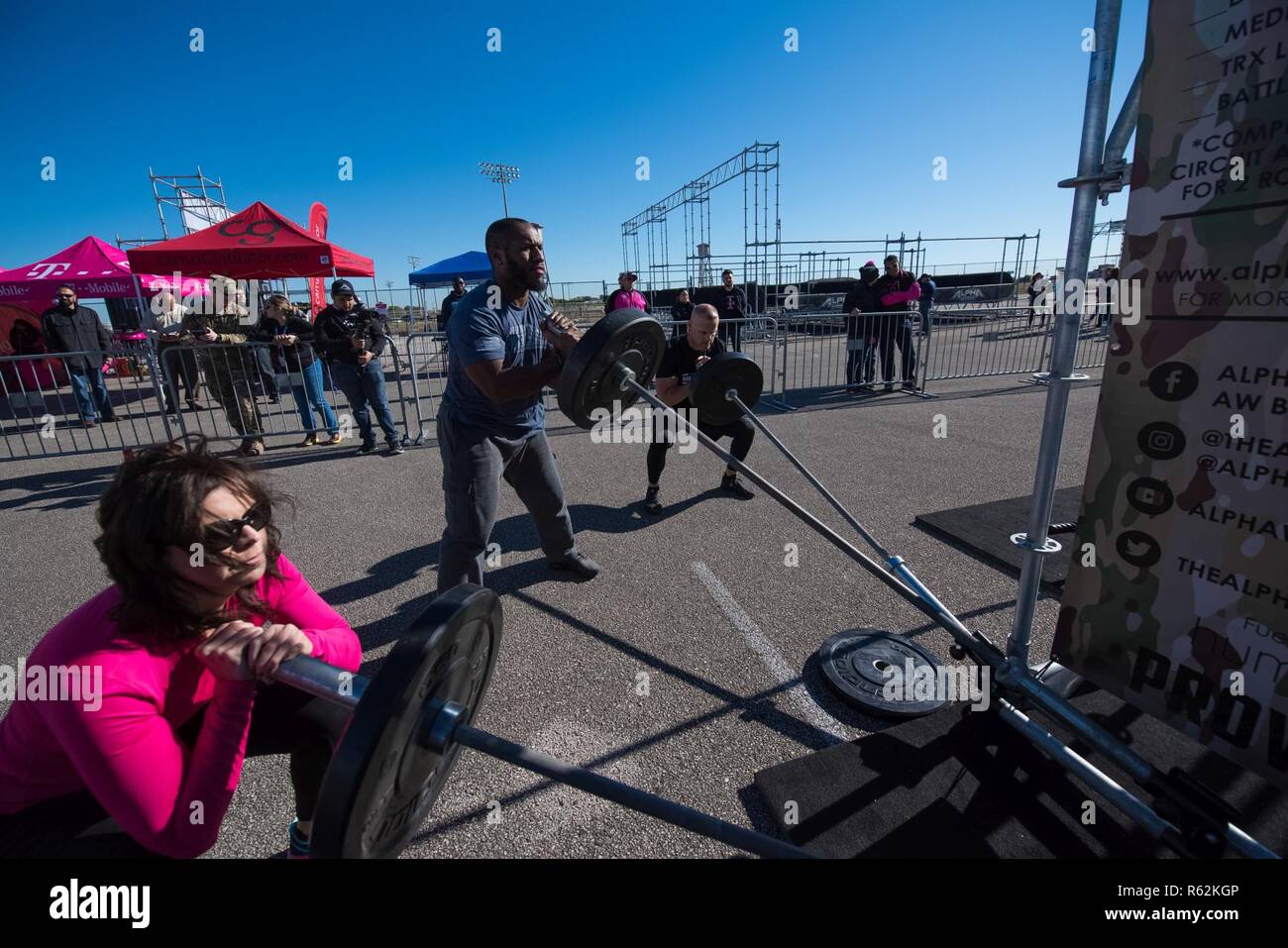 U.S. military and civilian members workout on a miniature obstacle rig ...