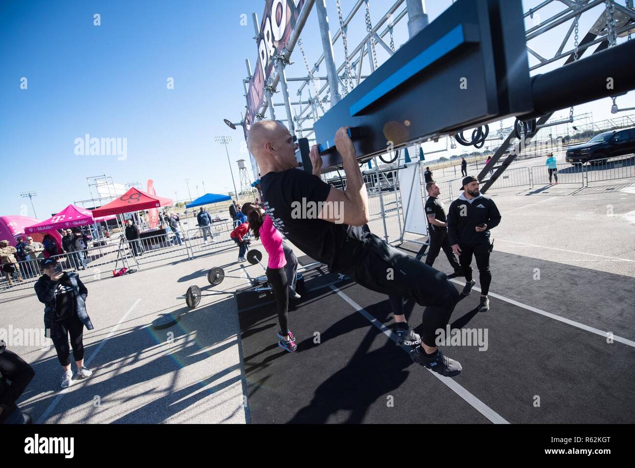 U.S. military and civilian members workout on a miniature obstacle rig ...