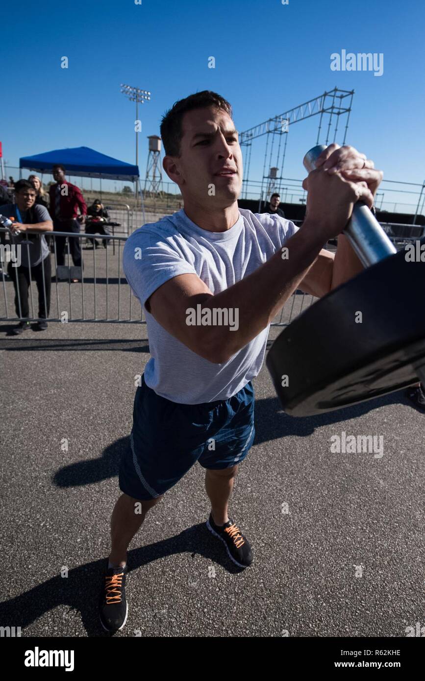 U.S. military and civilian members workout on a miniature obstacle rig ...