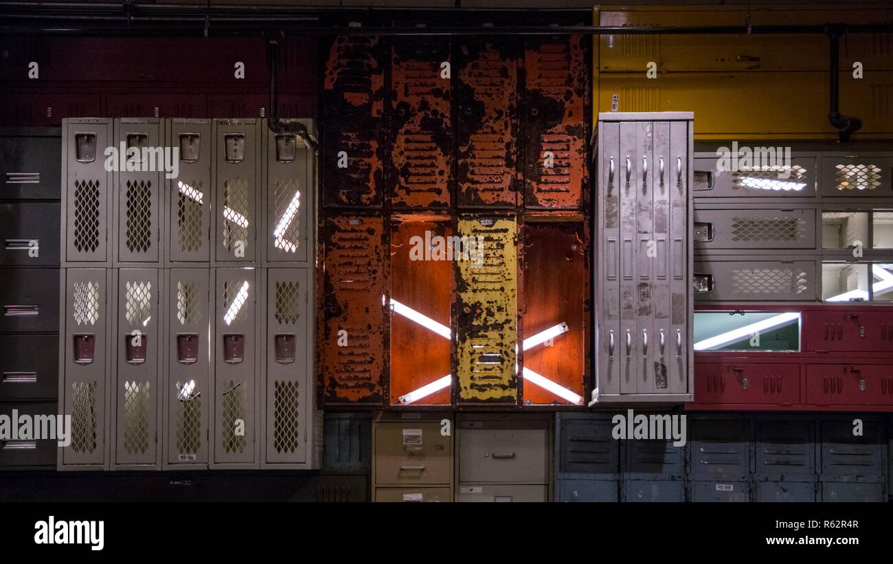 Wall of lockers lit up by neon light tubes Stock Photo - Alamy