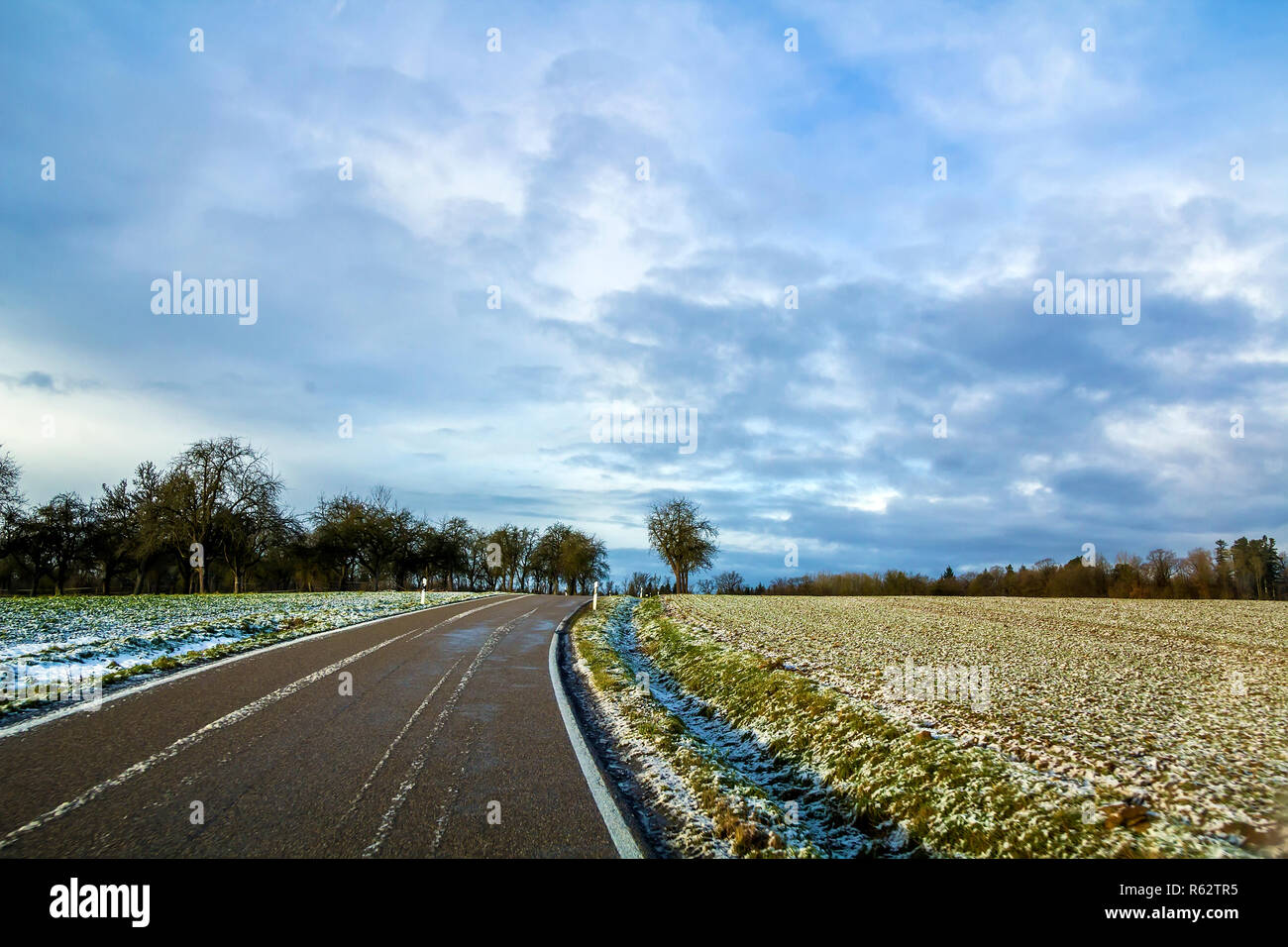 Empty black asphalt road between green fields Stock Photo - Alamy