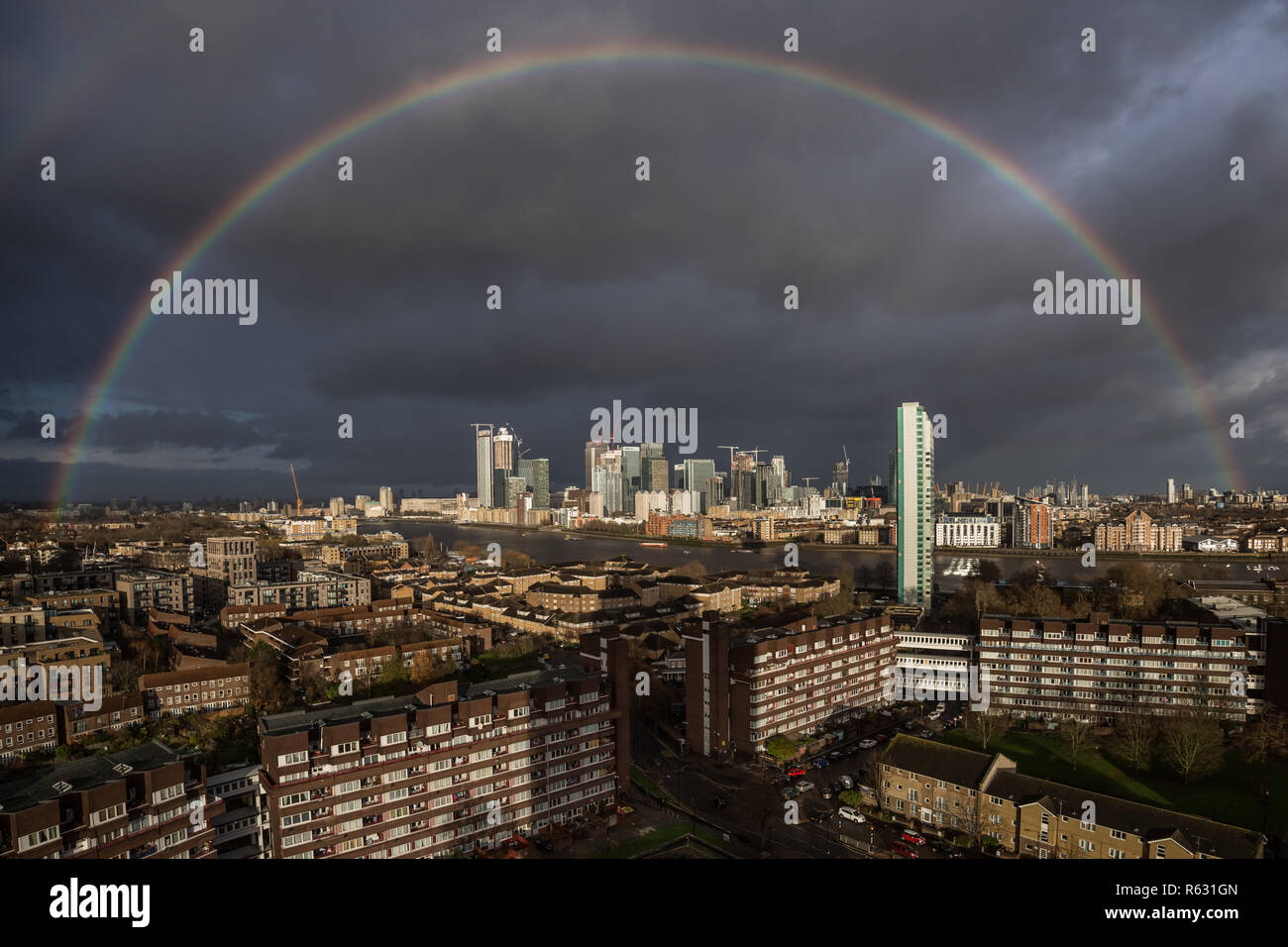 London, UK. 3rd December, 2018. UK Weather: A massive rainbow breaks ...