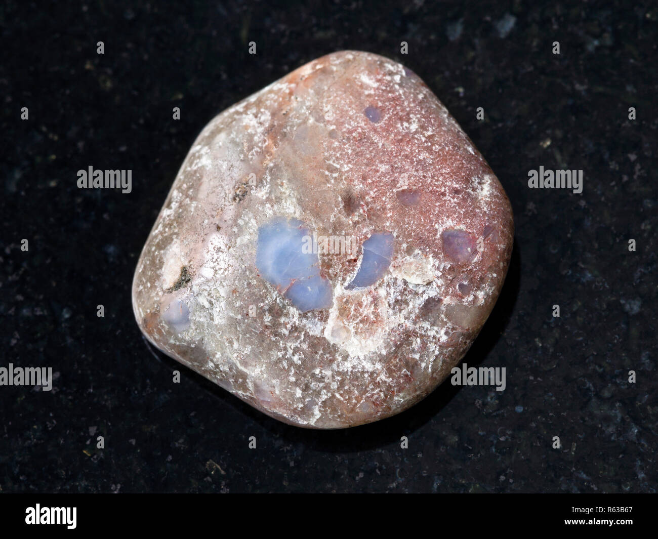 tumbled porphyry gemstone on dark background Stock Photo - Alamy