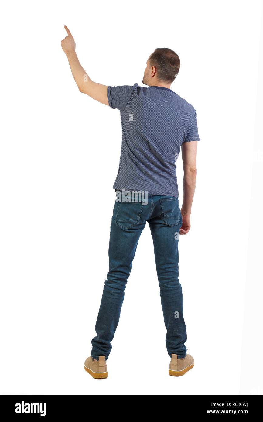 Back view of a man in jeans points his hand upwards. Rear view people ...