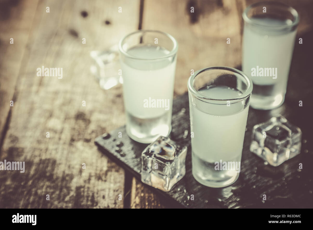 Traditional greek vodka - ouzo in shot glasses on rustic wood ...