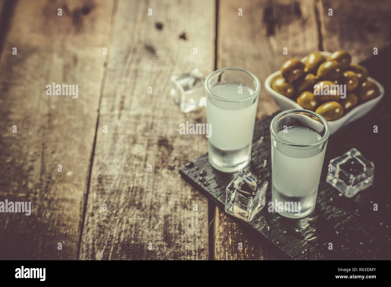 Traditional greek vodka - ouzo in shot glasses on rustic wood ...